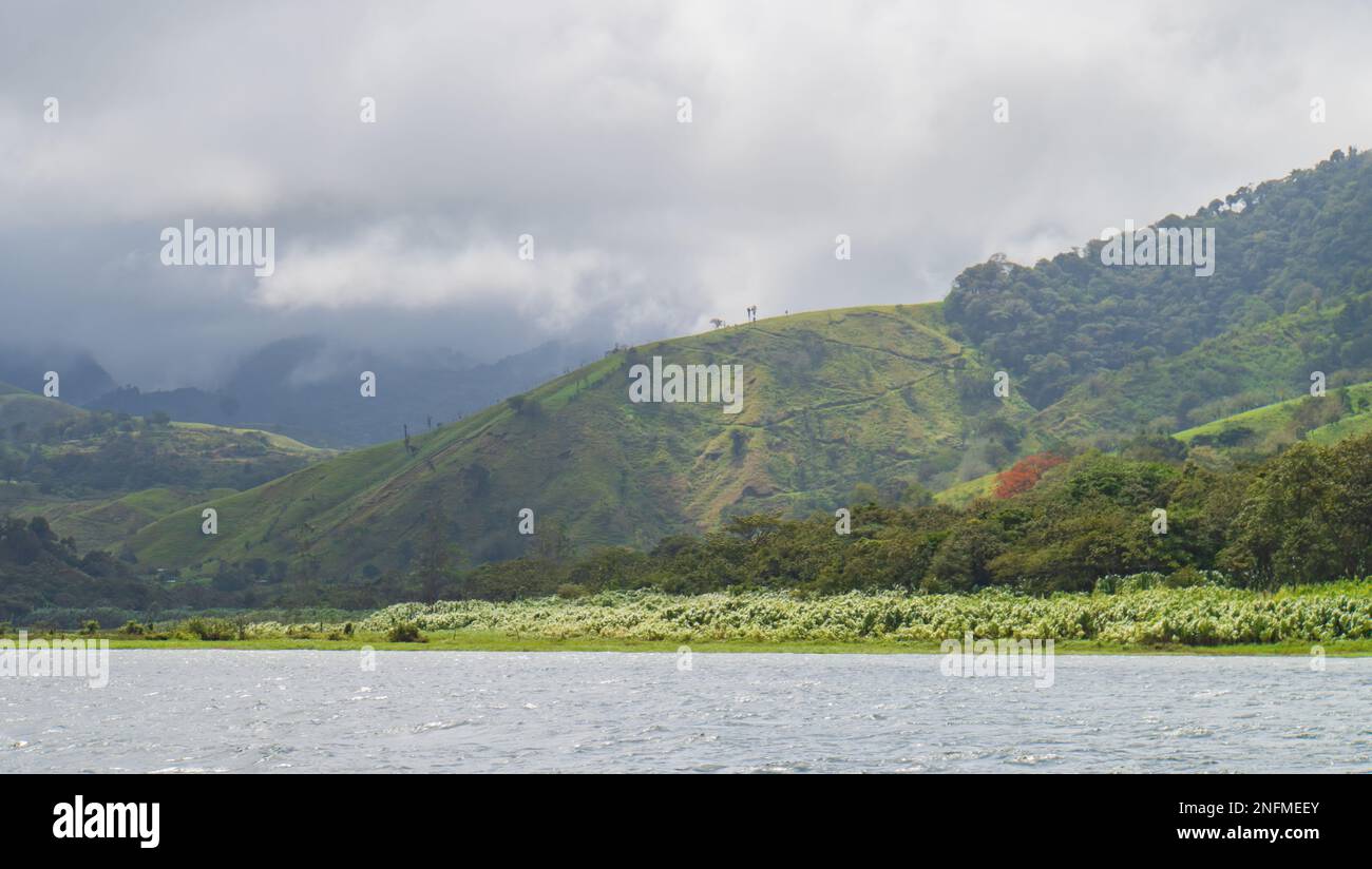 mist and clouds over the lush tropical landscape along Lake Arenal in ...