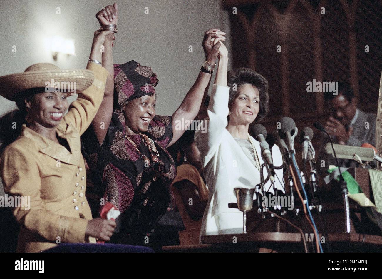 Winnie Mandela center, raises her arms with Jacqueline Jackson, wife of ...
