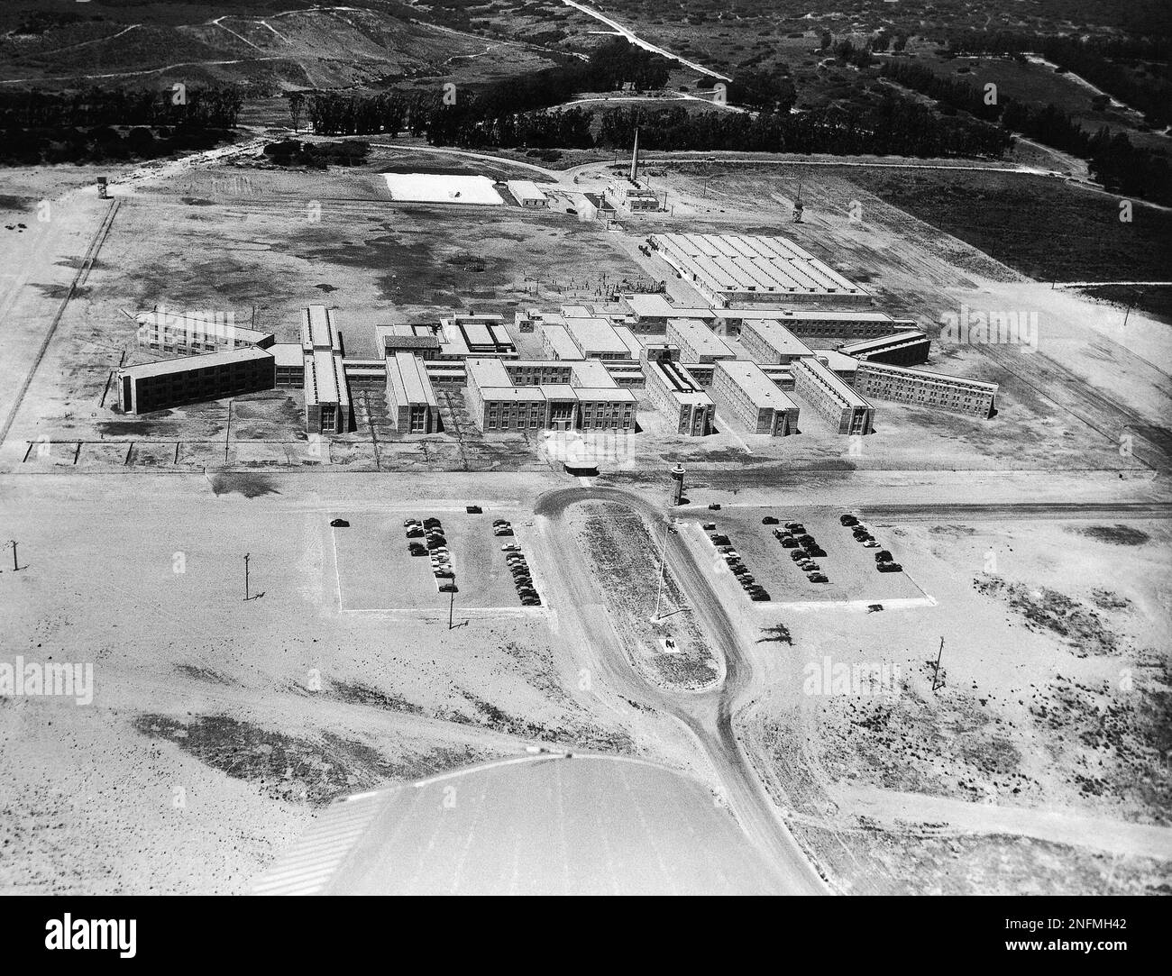 Inside an Electrically charged fence, dominated by four guard towers ...