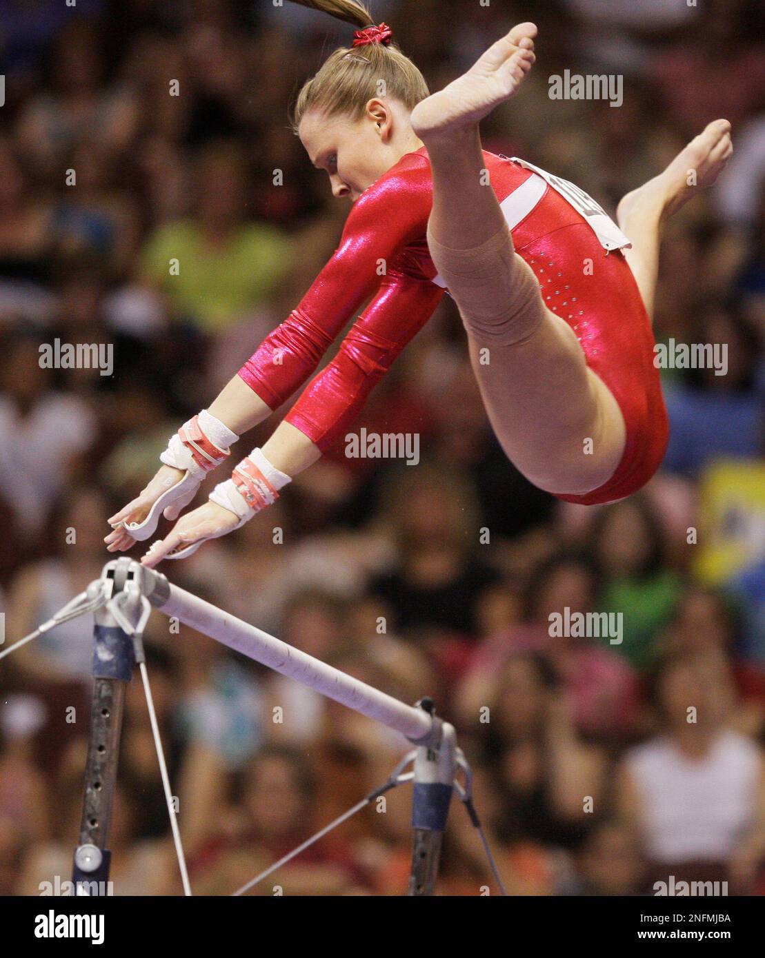 Bridget Sloan reaches out to grab the uneven bars during the women's ...
