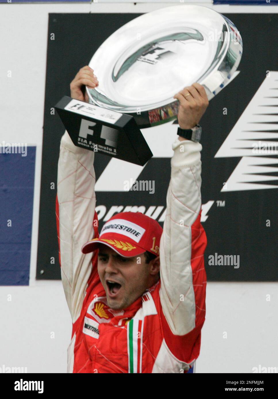 Ferrari driver Felipe Massa, of Brazil, holds the trophy on the podium ...