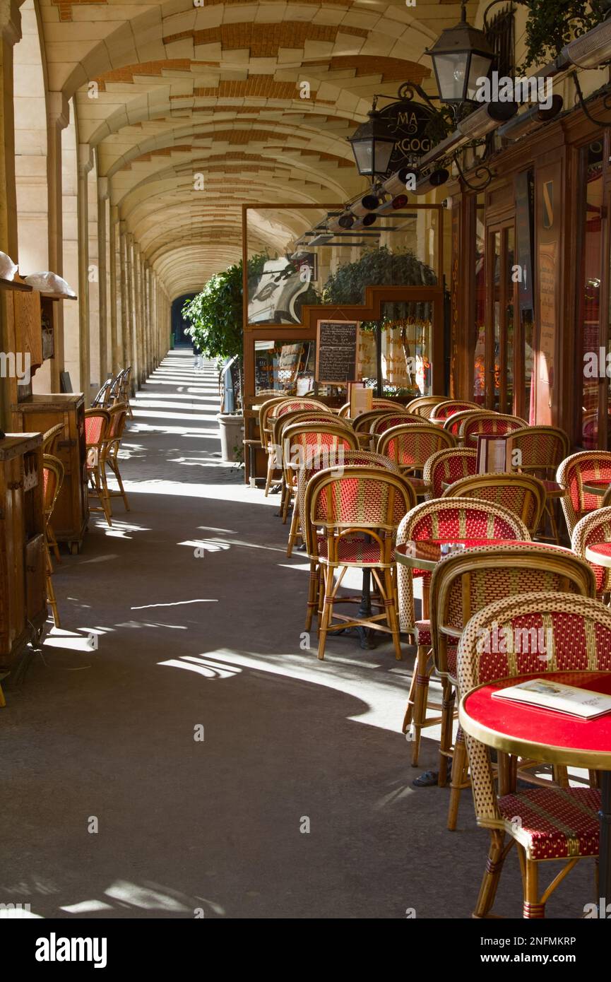Cafe With Chairs And Tables In A Sunlit Arcade In The Place De Vosges ...