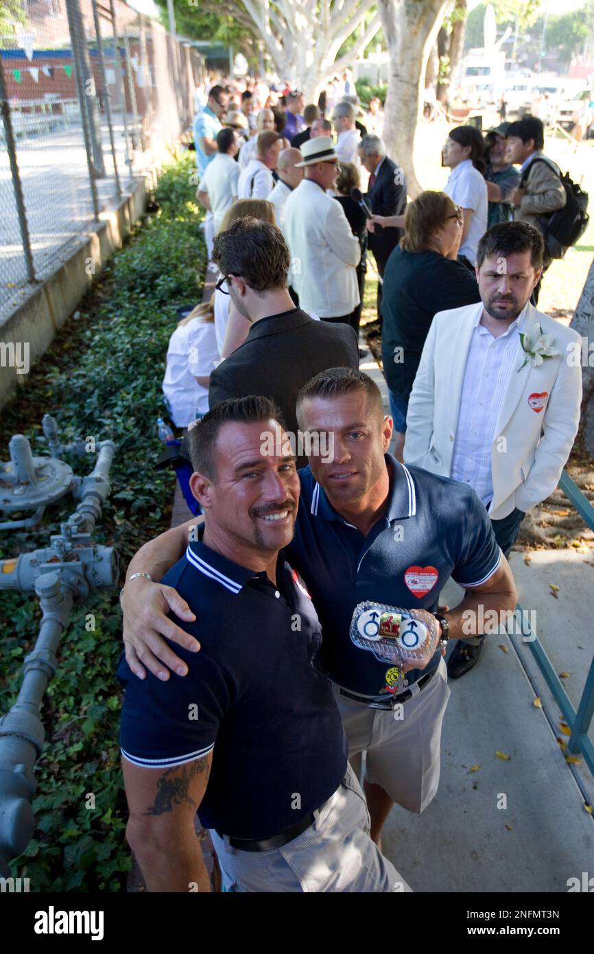 Rob Peters (L) and his partner John Martell wait in line to get their ...