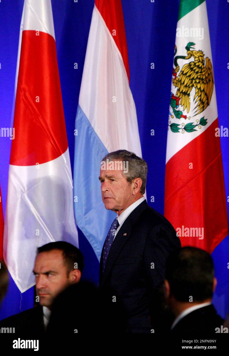 U.S. President George Bush walks past flags, from left: Japan ...