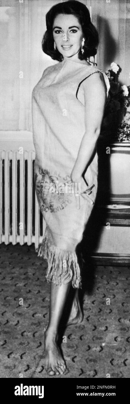 Actress Liz Taylor peers directly into camera as she models a sugar bag ...