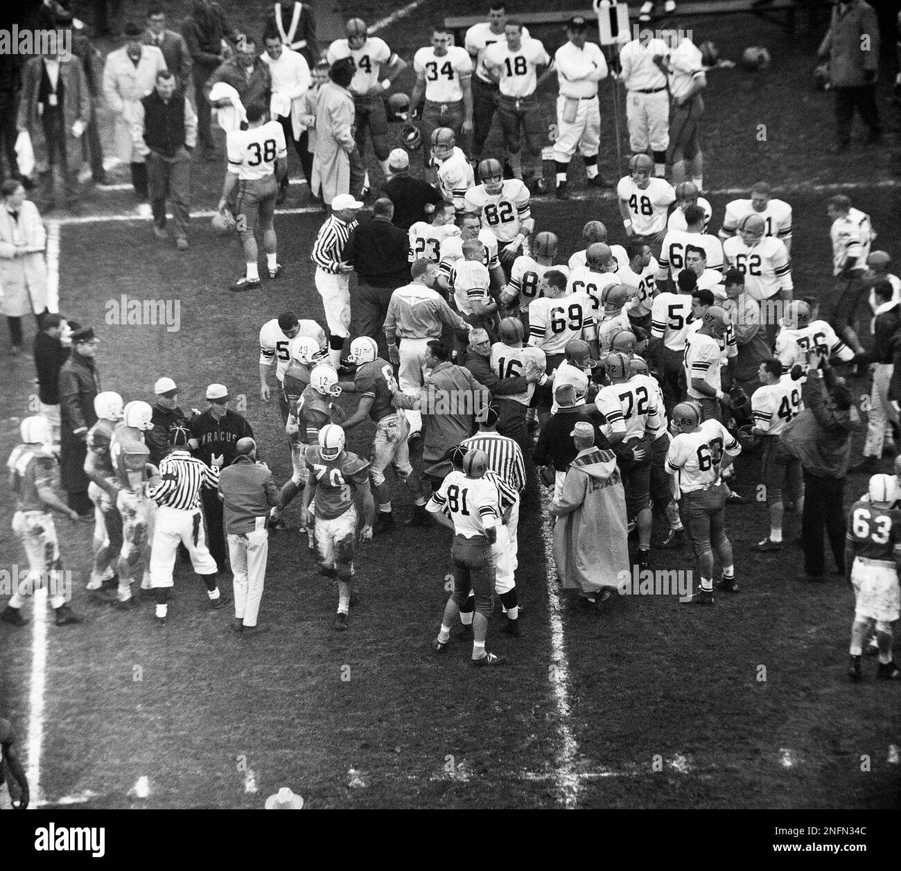 Syracuse University coach Ben Schwartzwalder, center, puts his arms ...