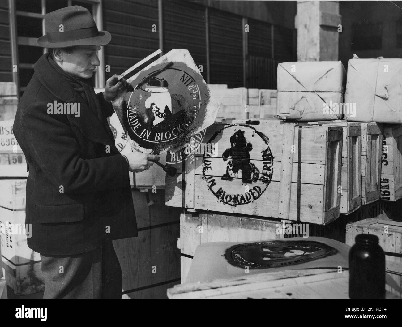 A German worker screen prints wooden transport boxes with the trade ...