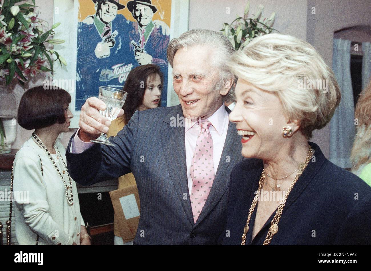 Actor Kirk Douglas, along with his wife Anne, raises his glass to ...