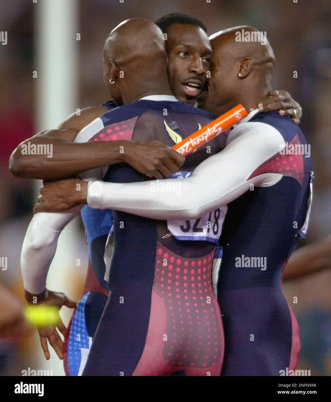 U.S. runner Michael Johnson, center, embraces teammates Calvin Harrison ...