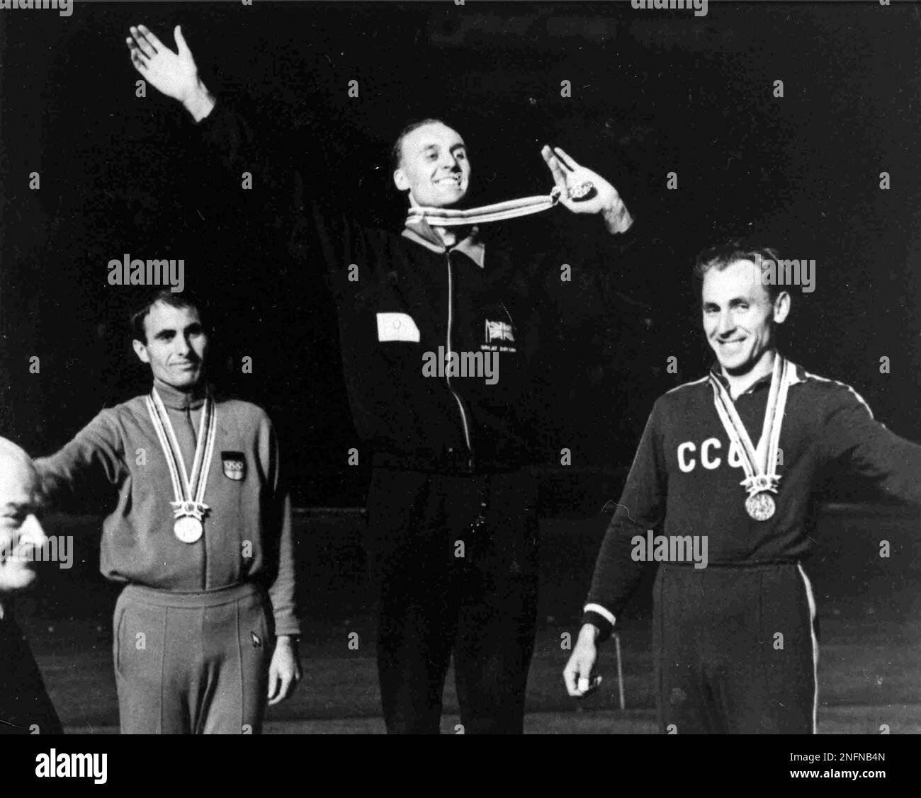 Britain's Ken Matthews, centre, proudly displays his gold medal after ...