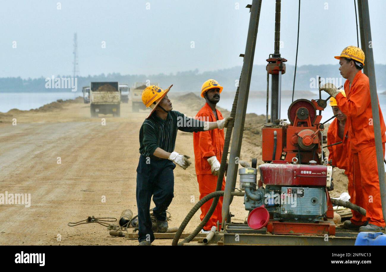 The Chinese construction workers bore hole in the harbor bed at the ...