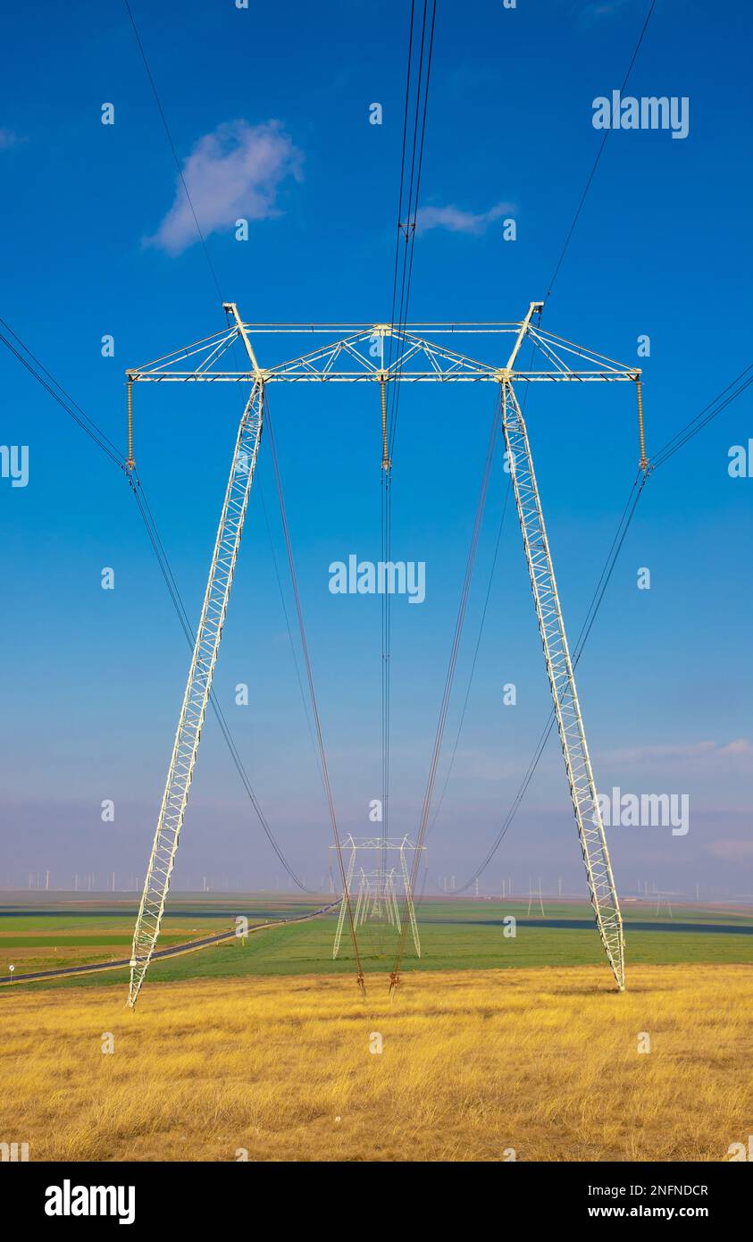A high voltage pylon and lines on a field against a bue sky Stock Photo ...