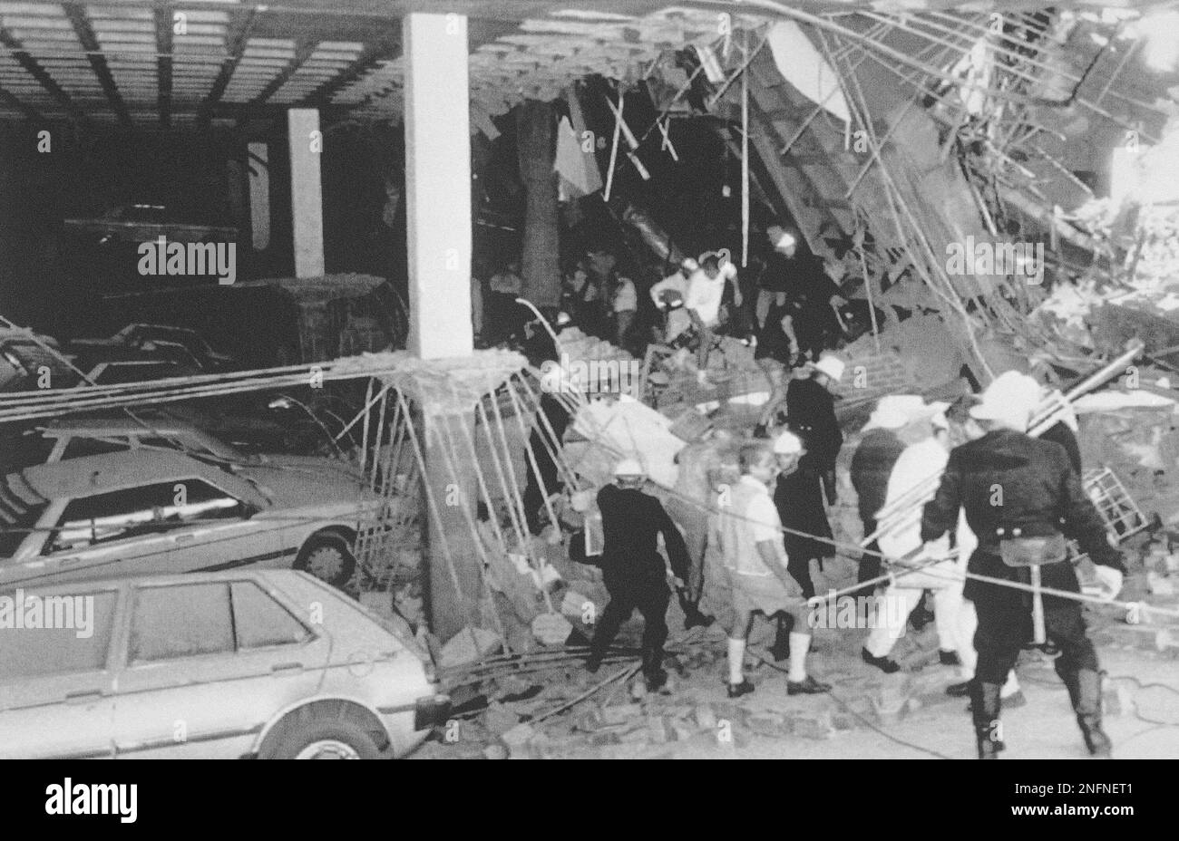 Rescue workers and onlookers look at damaged buildings caused in ...