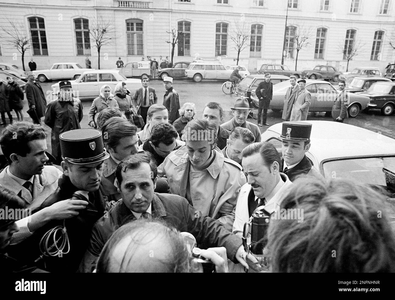 Actor Alain Delon, center, pushes his way through the crowd of ...