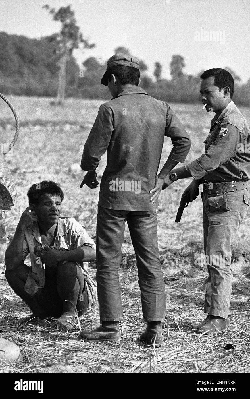 A South Vietnamese officer, right, holds a pistol as he and interpreter ...
