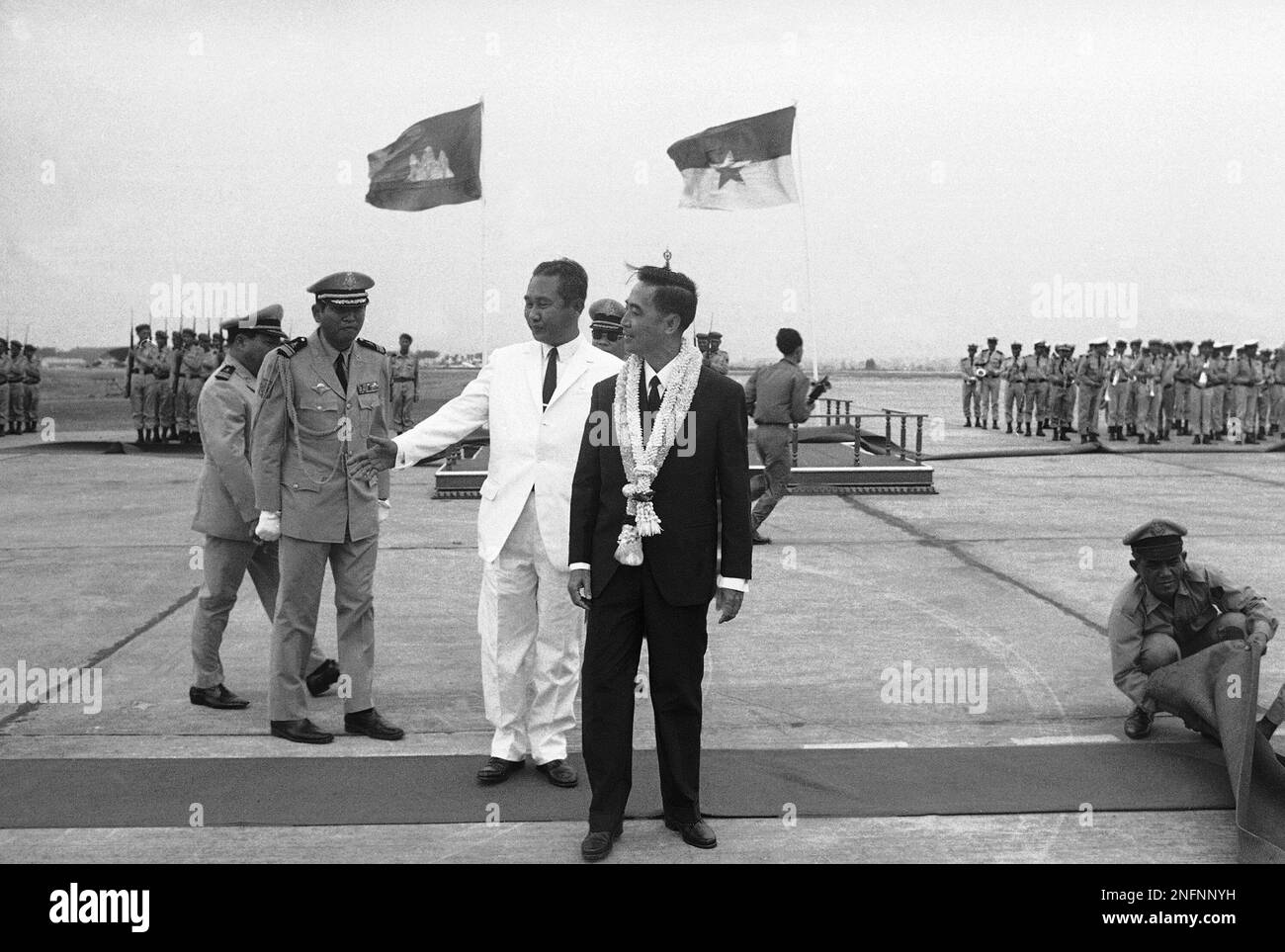 Acting Premier Gen. Lon Nol, in white suit, gestures for Huynh Tan Phat ...