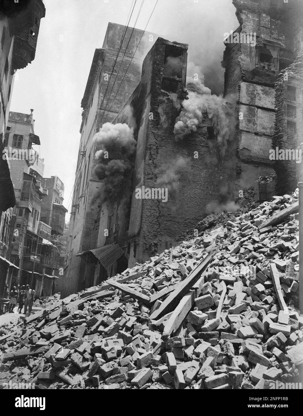 A still burning building stands amid the ruins of other buildings at ...