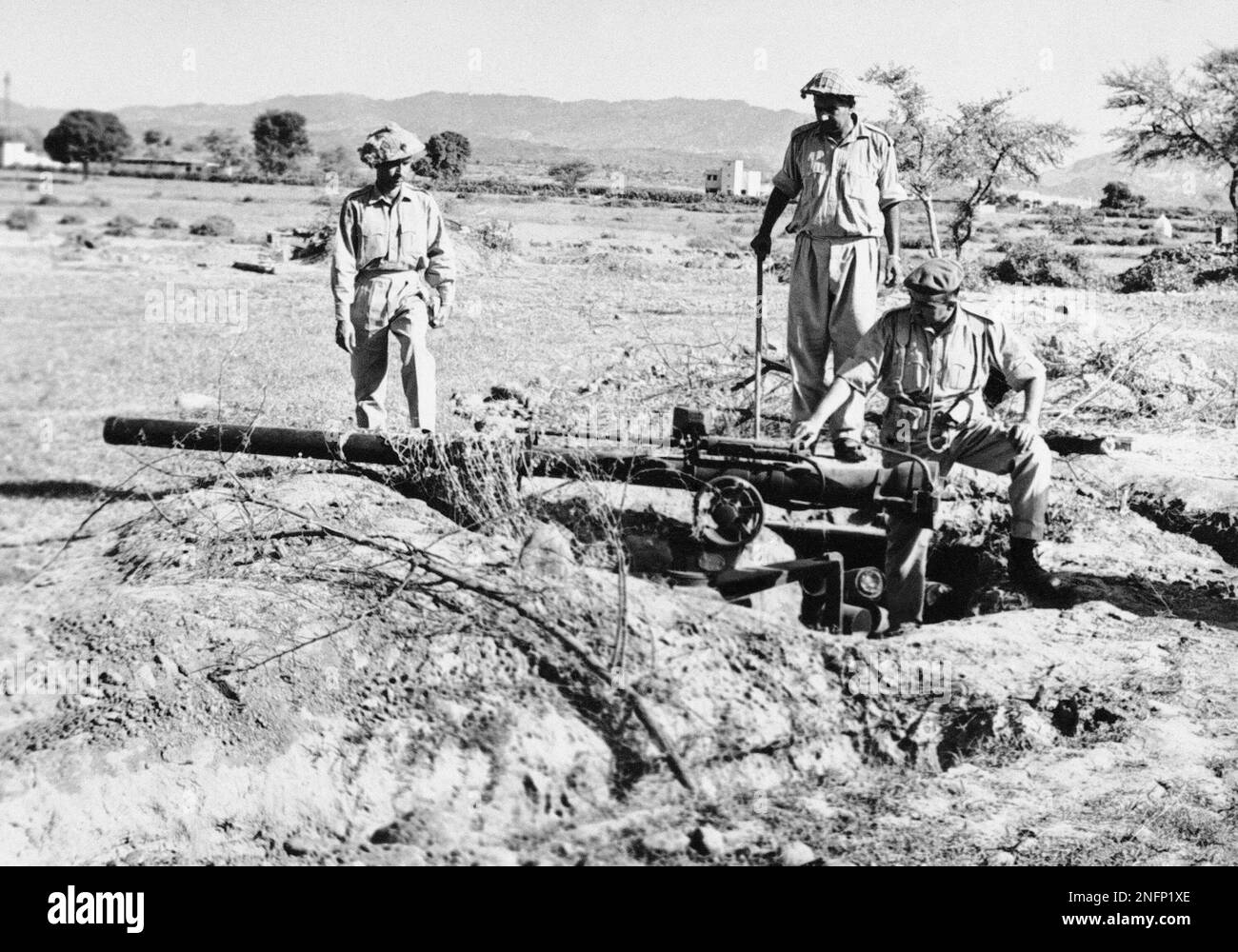 Pakistani and Azad Kashmir Troops stand beside a gun which they claim ...