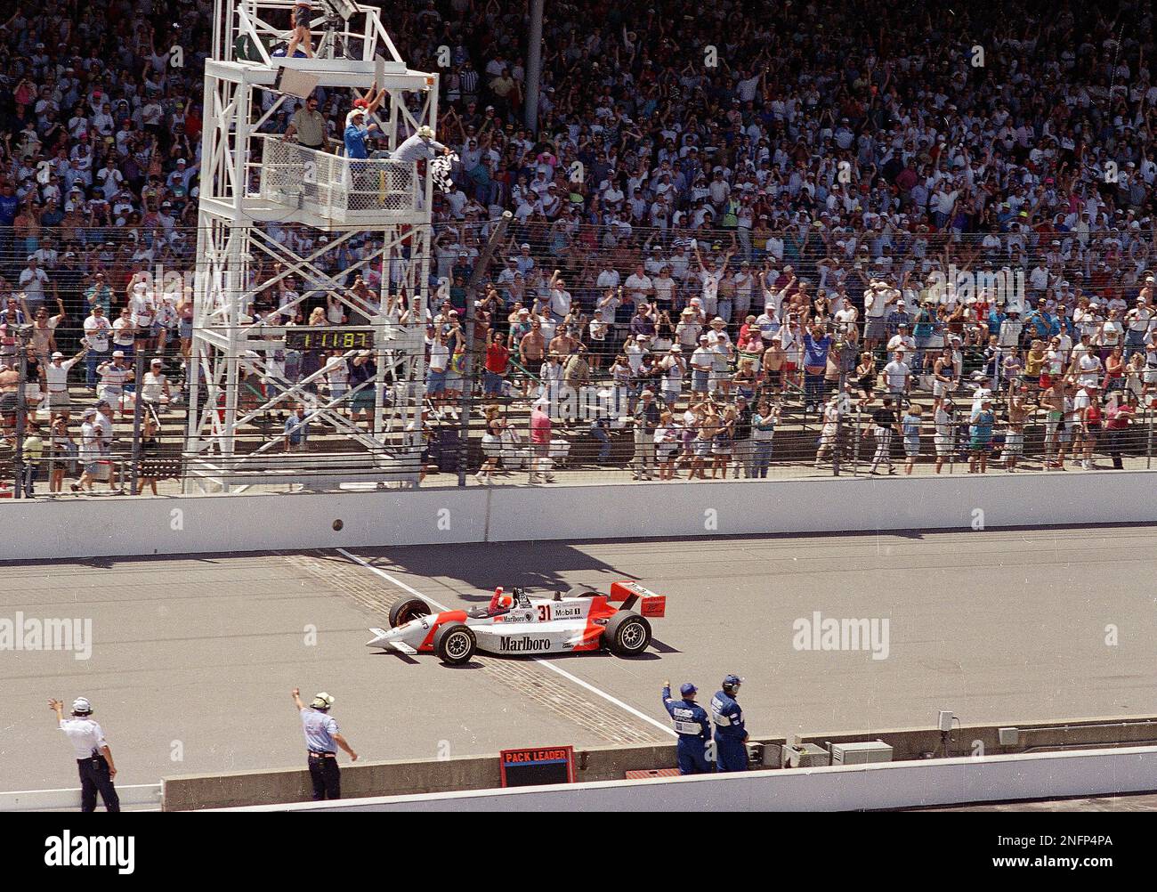 Al Unser Jr. waves a fist as he crosses the finish line and receives ...