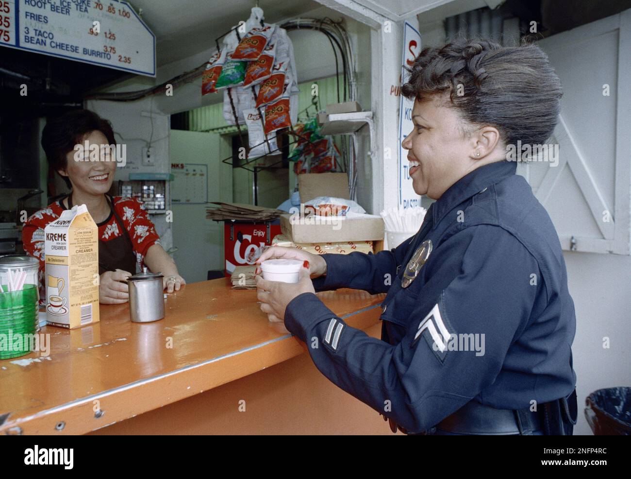 Los Angeles police officer Kyle Tolliver, right, gets lunch from Jean ...
