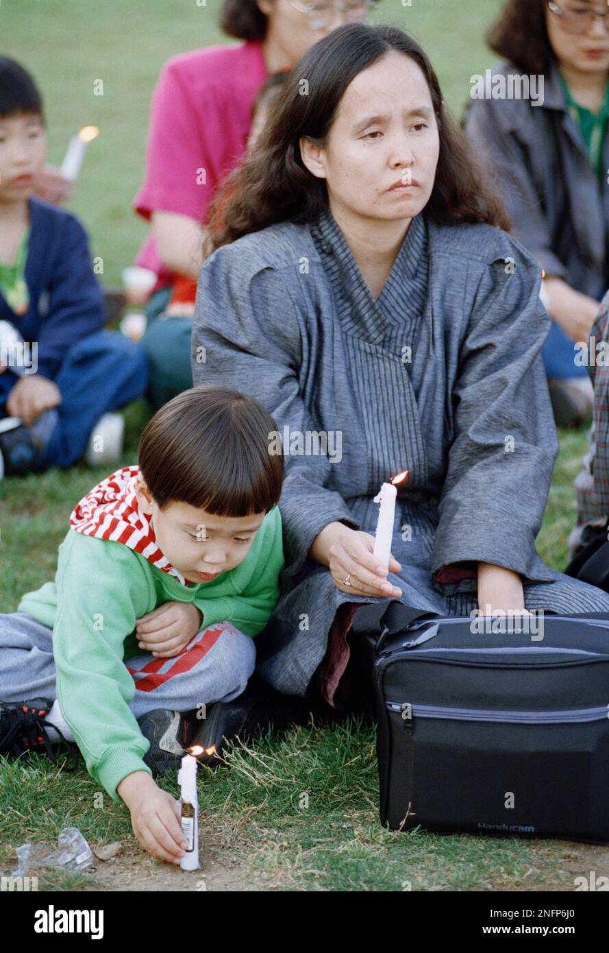 Juna Byun lights candles with her son George Le, 4, at the beginning of ...