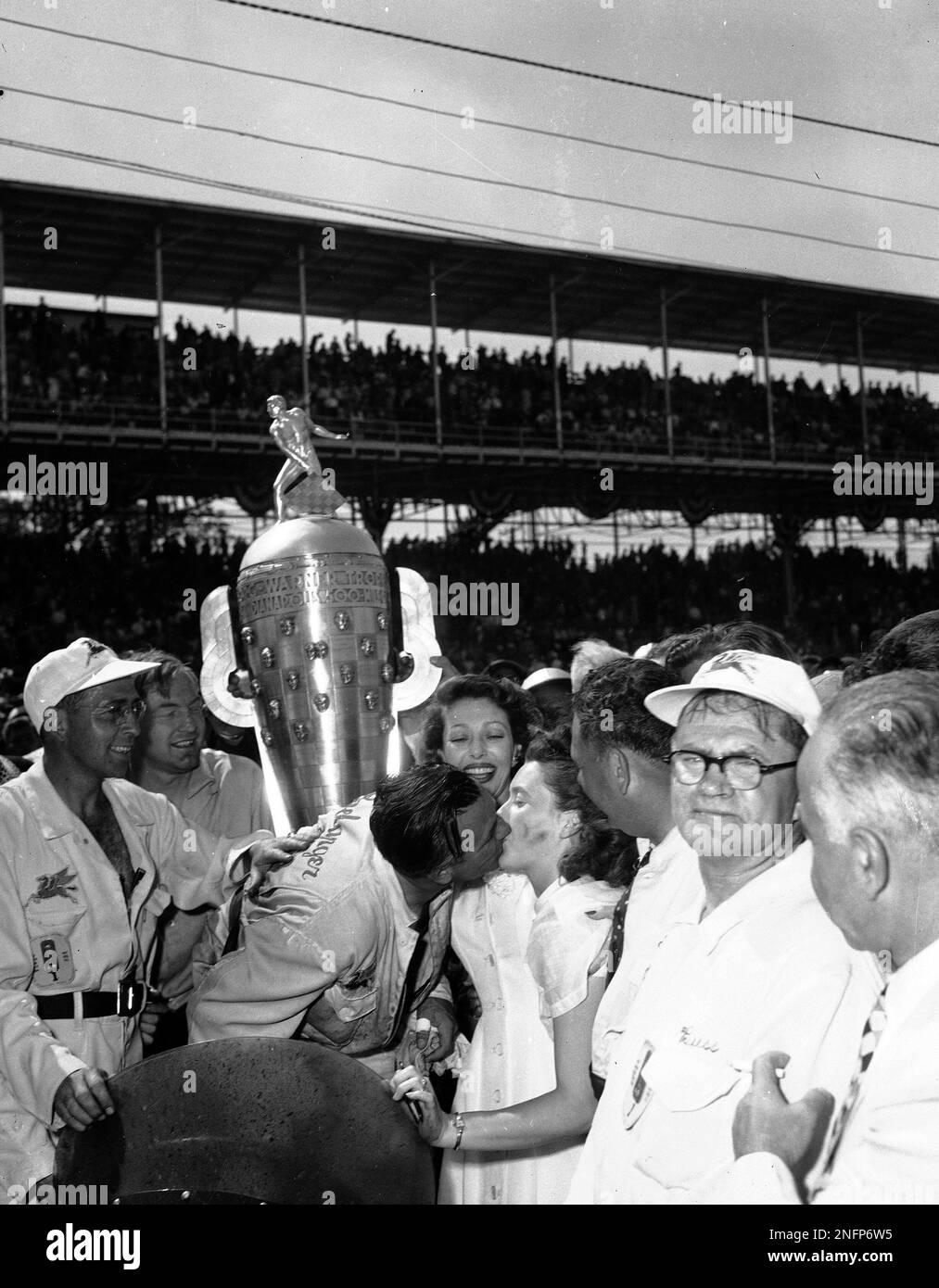 Movie actress Loretta Young (center) stands by the trophy and smiles ...