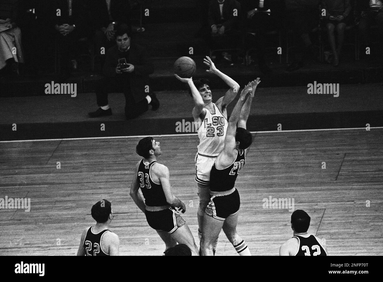 Pete Marvich of LSU levels with an opponenet who vainly tries to block ...