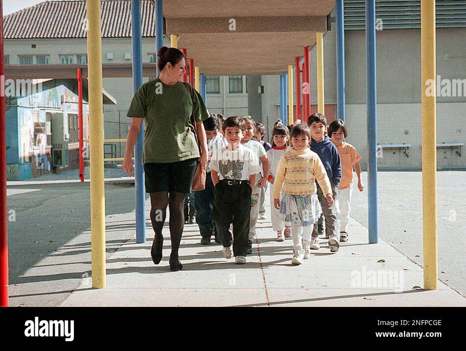 Teachers aid Mirna Jimenez walks with her kindergarten class through ...