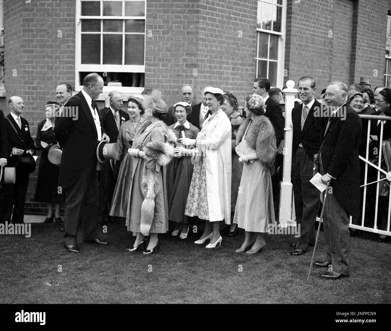 Britain's Queen Elizabeth II, second left, talks with her horse trainer ...