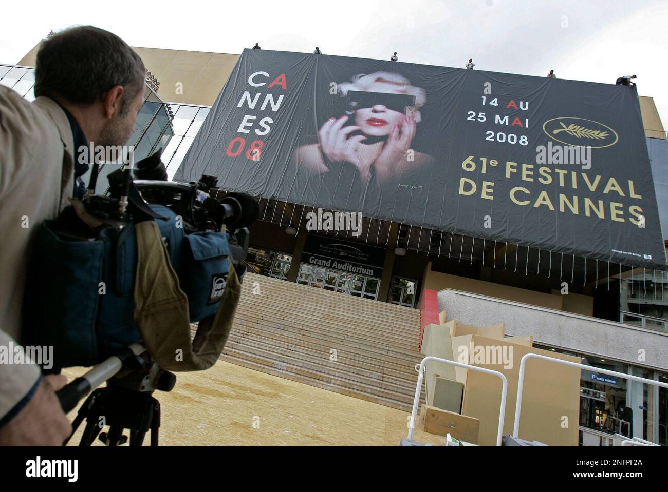 A cameraman films the giant poster above the main entrance of the ...