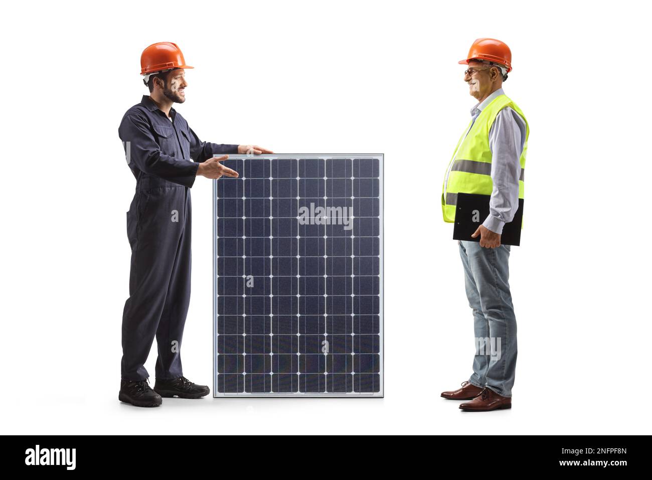 Worker in a uniform and helmet presenting a solar panel to a mature ...