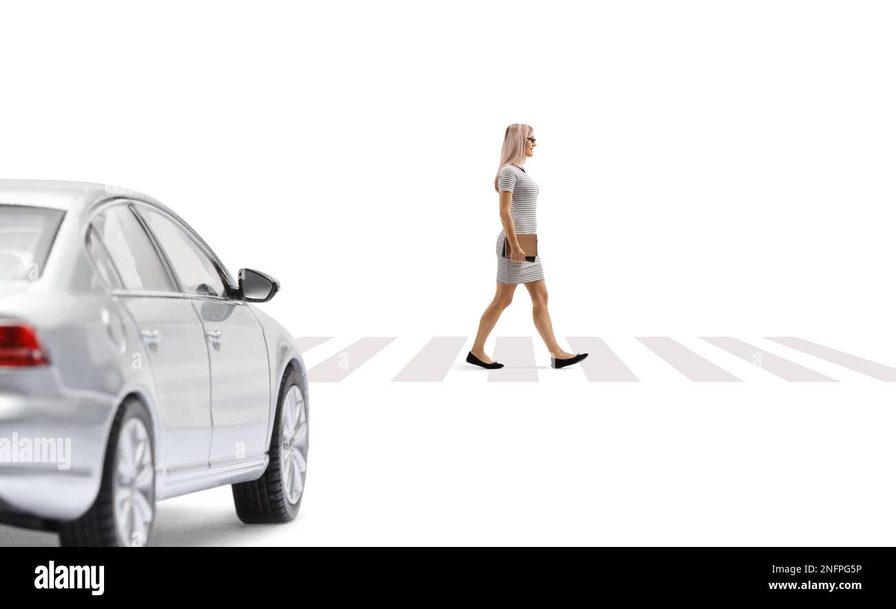 Car stopping at pedestrian crossing and a woman crossing street ...