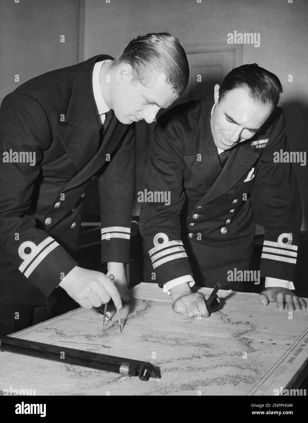 The Duke of Edinburgh, left, examines a chart with Commander W.G.F ...
