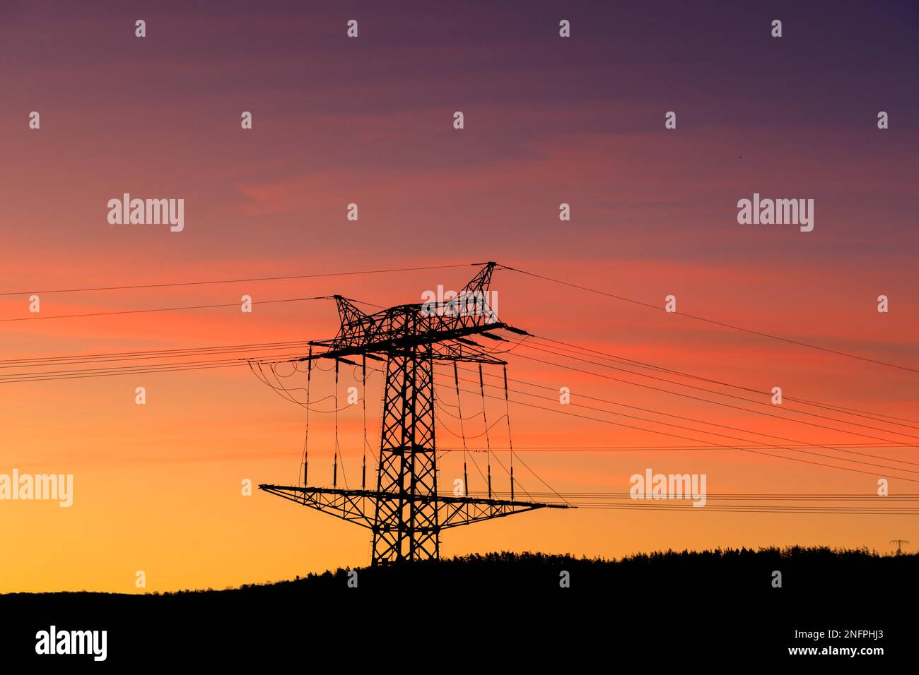 High voltage pylon overhead line in the sunset Stock Photo - Alamy