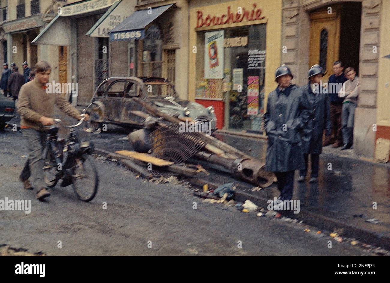 A man walks his bicycle past some guards on a street in the Latin ...