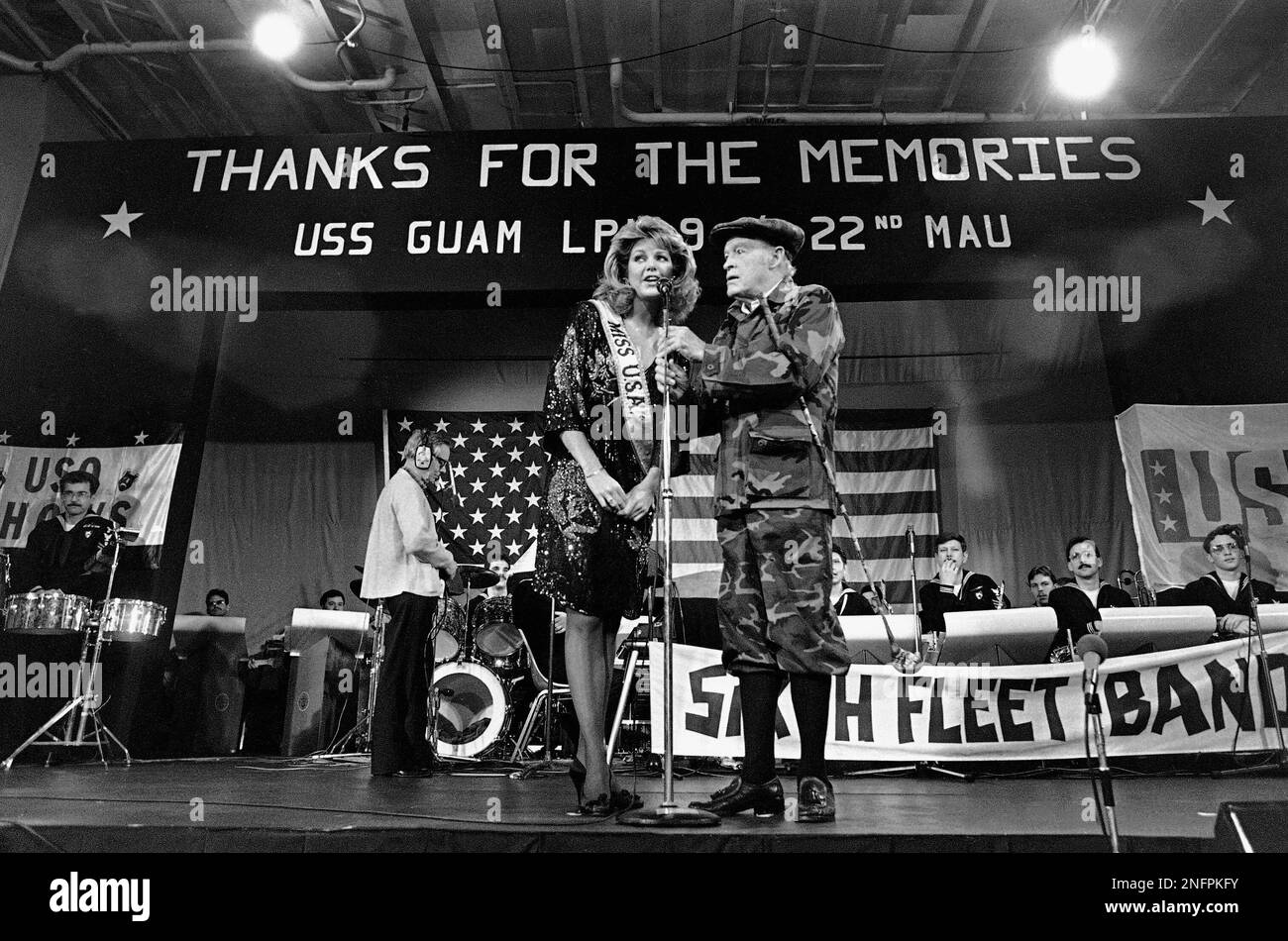 Comedian and entertainer Bob Hope, wearing a camouflage suit, clowns ...