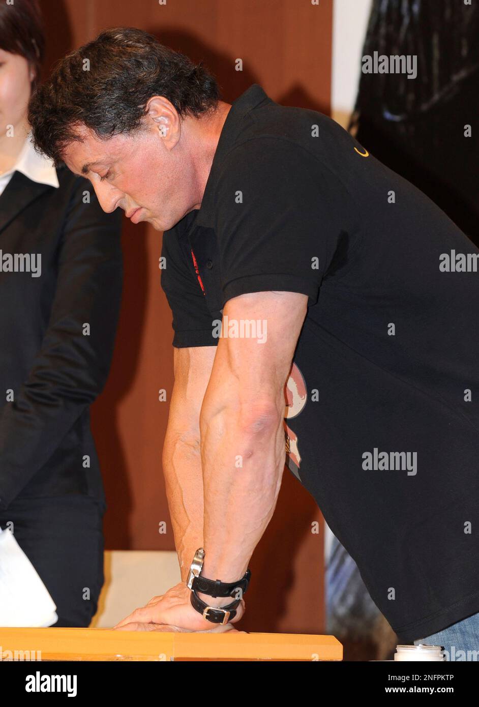 Actor Sylvester Stallone pushes his hand on a mold for a hand print ...