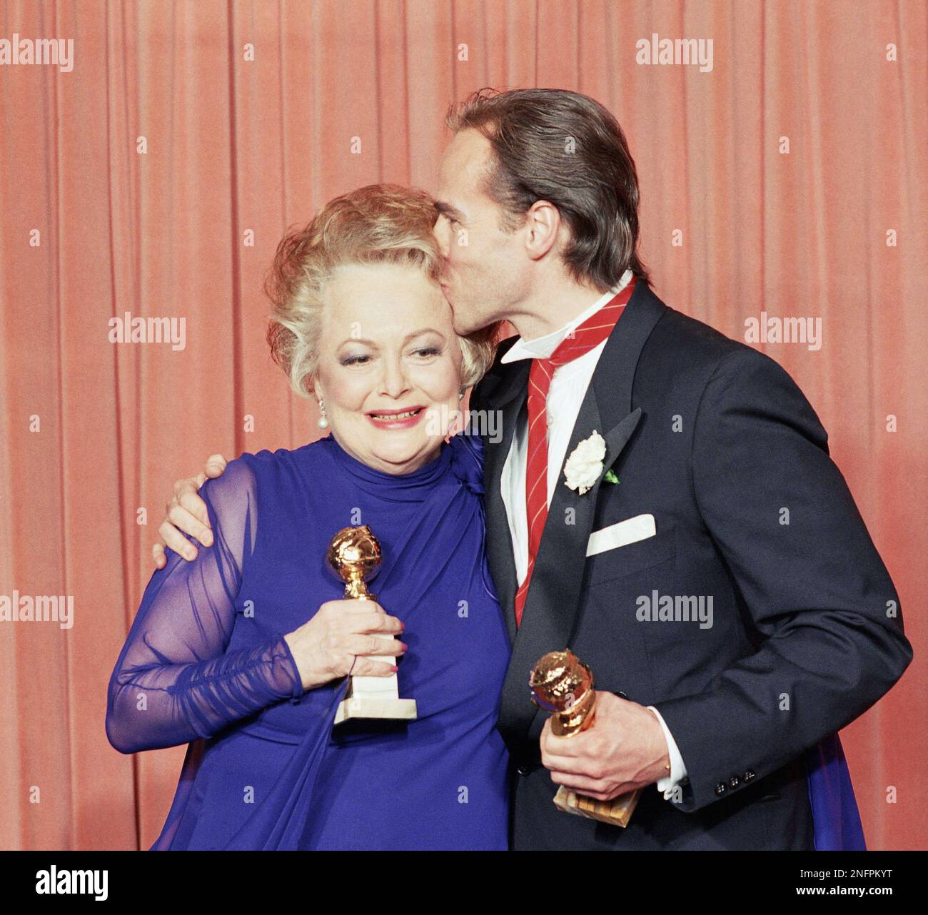 Actress Olivia de Havilland holds her Golden Globe Award and gets kiss ...