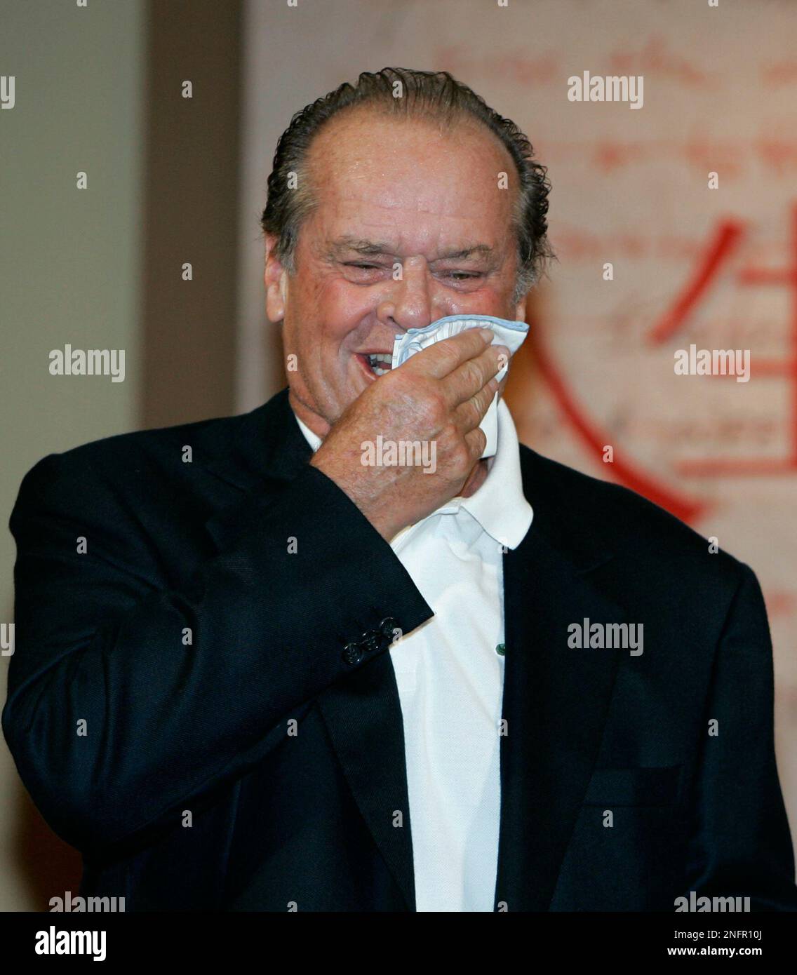 U.S. actor Jack Nicholson smiles while wiping his face at a press ...