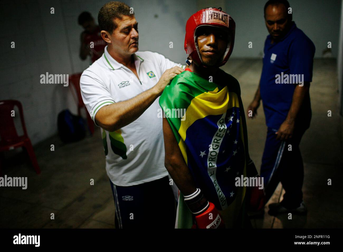 A coach hangs a Brazilian flag from Brazilian boxer Robson Coinceicao's ...