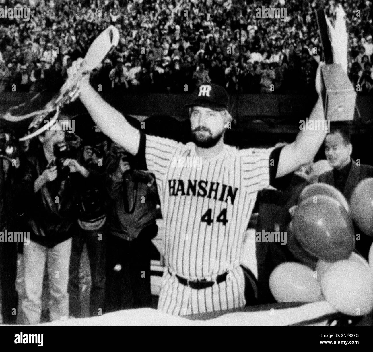 Randy Bass, first baseman for the Hanshin Tigers holds a trophy in his ...