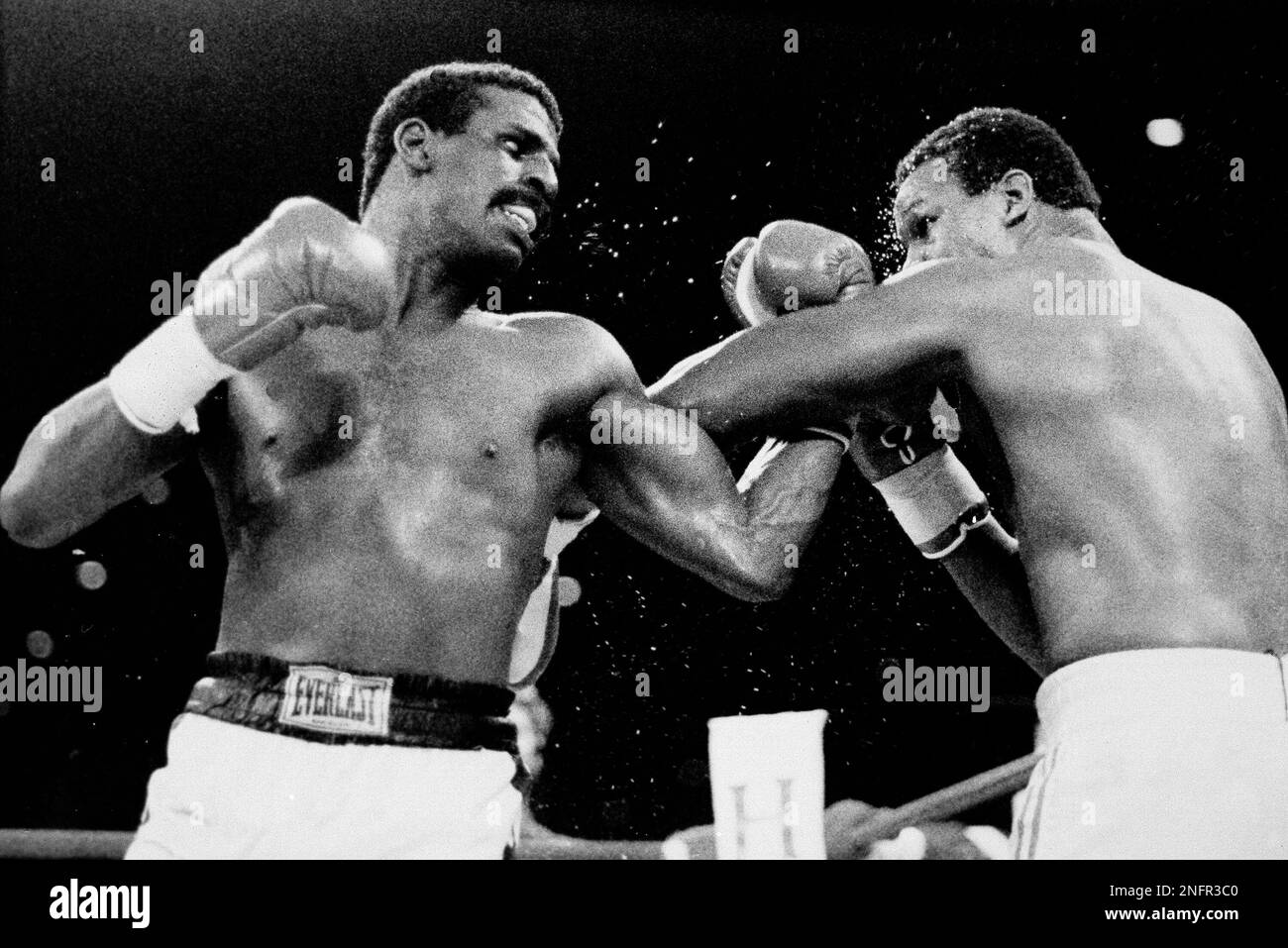 Michael Spinks, left, and Larry Holmes get tied up in an exchange ...