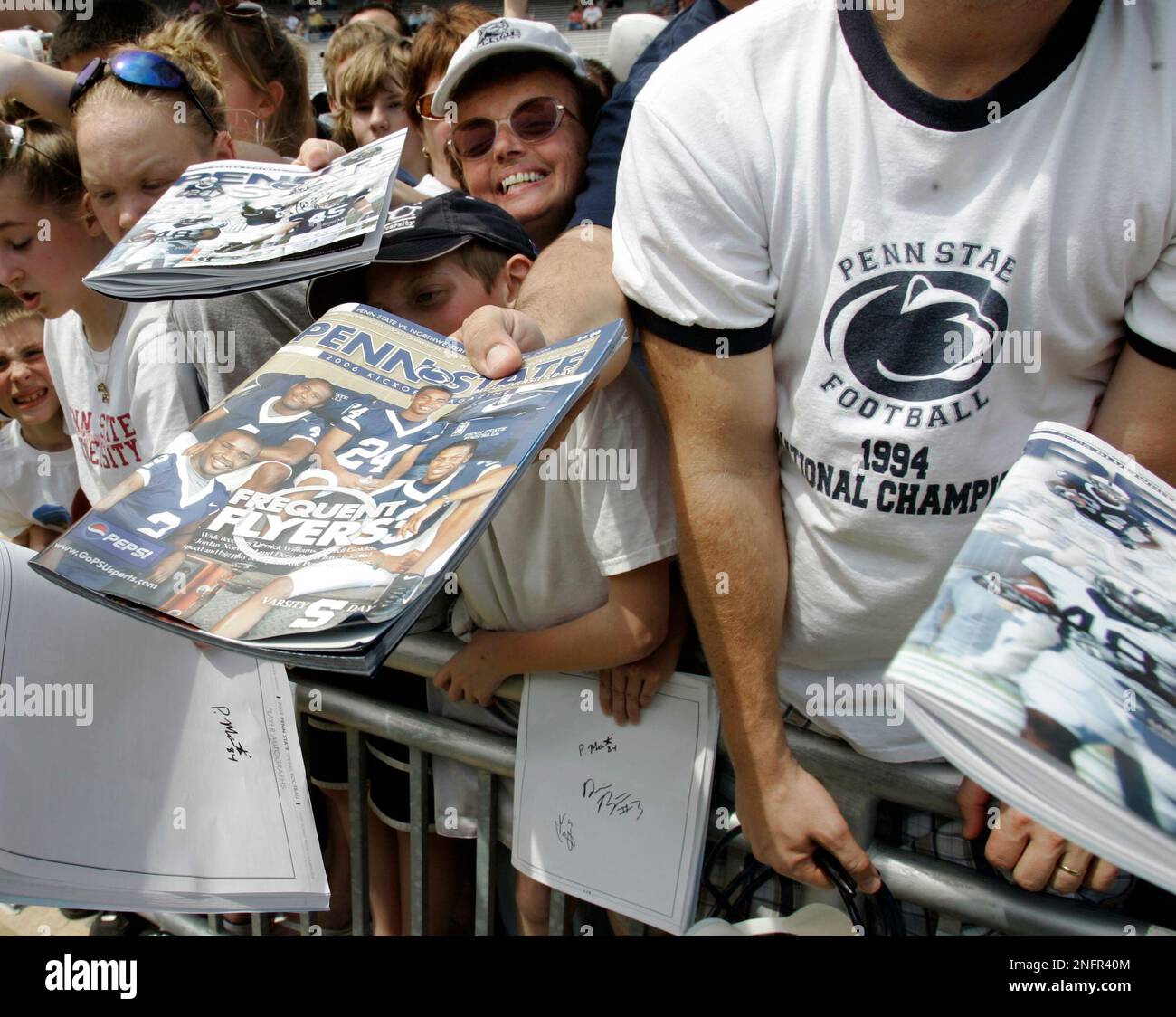 Penn State fans hold out items to be autographed by players before the ...
