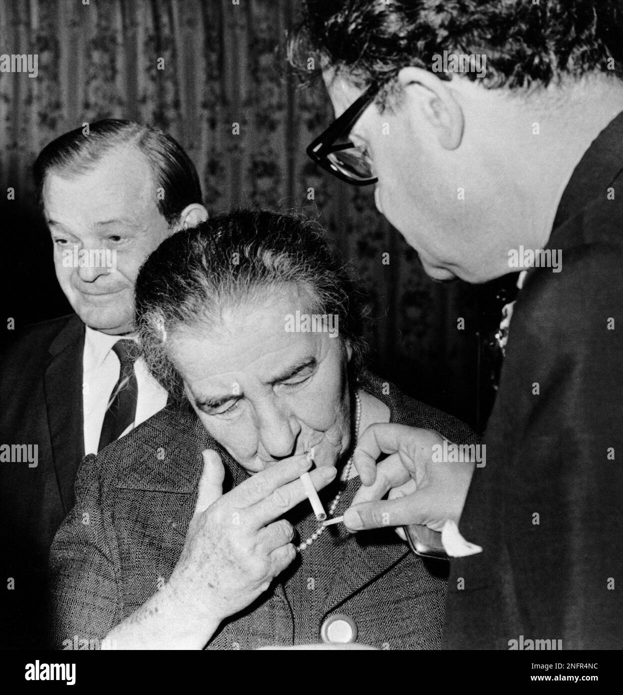 Israeli Prime Minister Mrs. Golda Meir pauses to have her cigarette lit ...