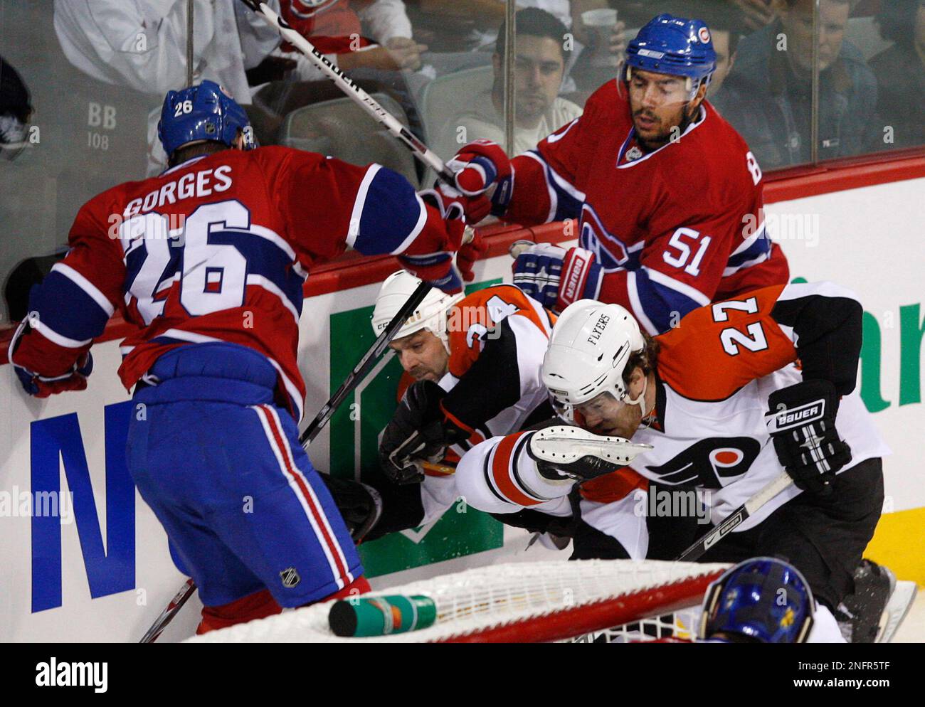 Philadelphia Flyers' Jim Dowd (34) and Steve Downie (27) are checked by ...
