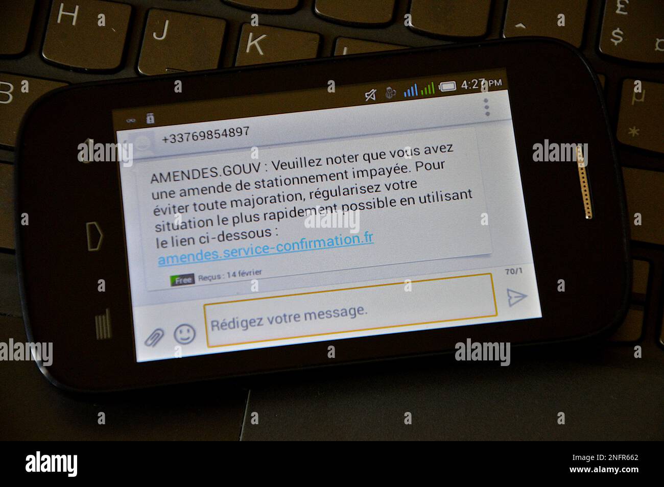 In this photo illustration, a fraudulent message is seen on a cell ...