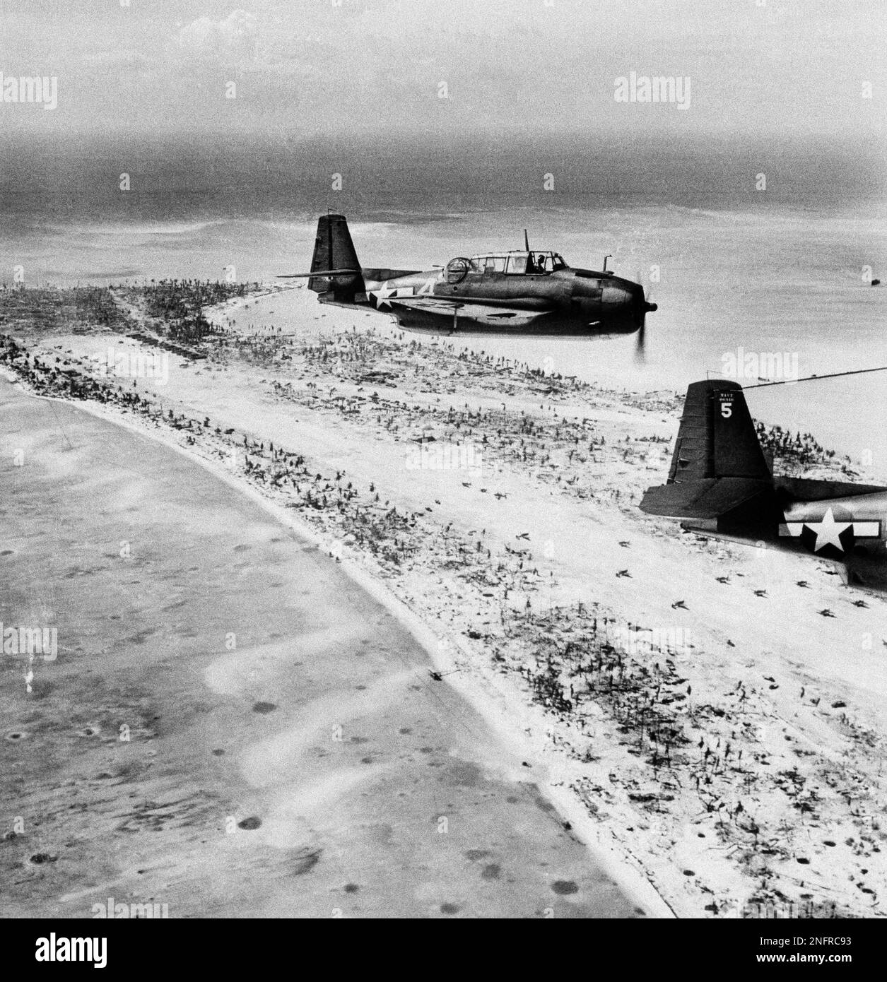 American Grumman TBF, torpedo-bomber planes, fly over Betio Island of ...