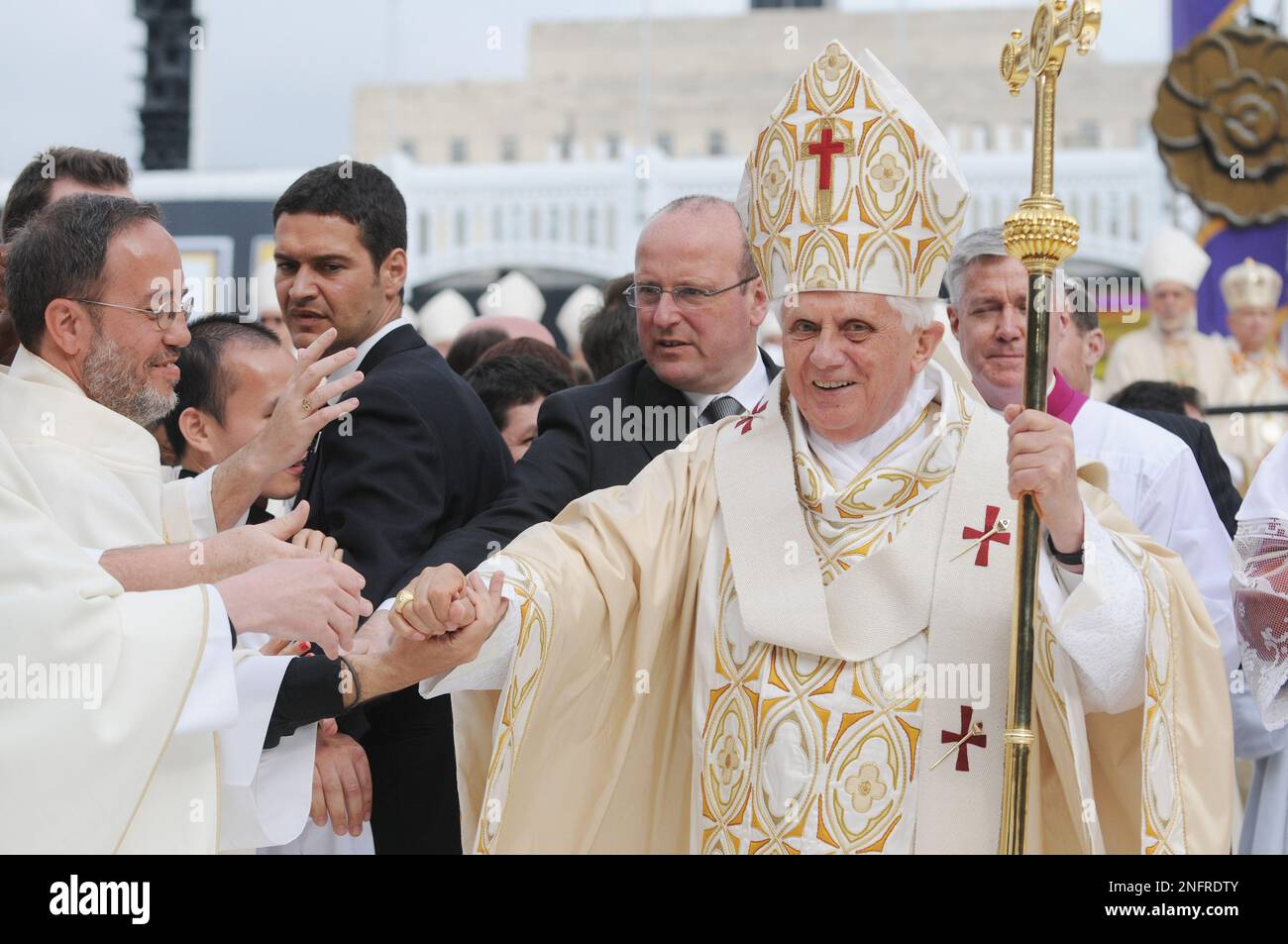 Priests reach out to touch Pope Benedict XVI as he leaves the altar at ...