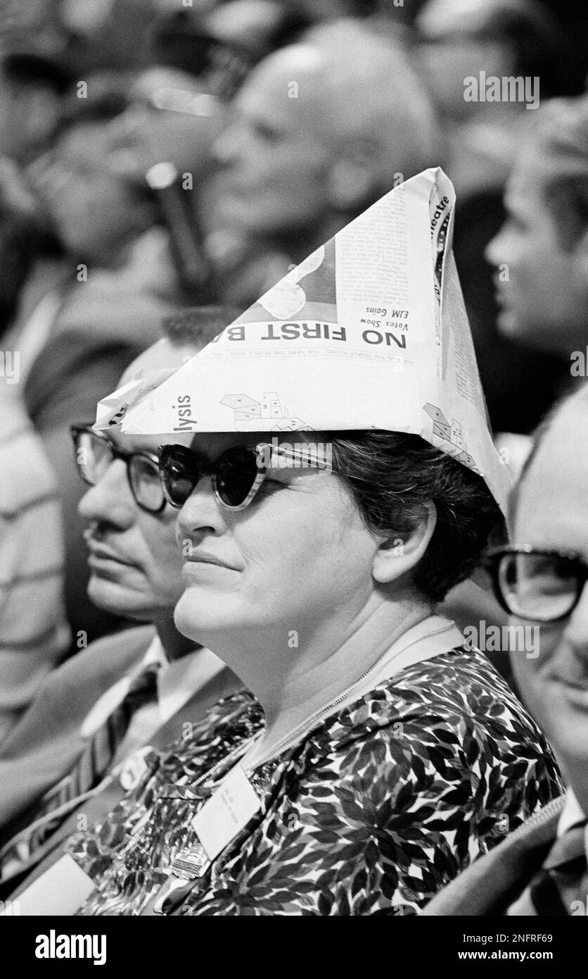 Wearing sunglasses and a cap shading her eyes made from a folded ...