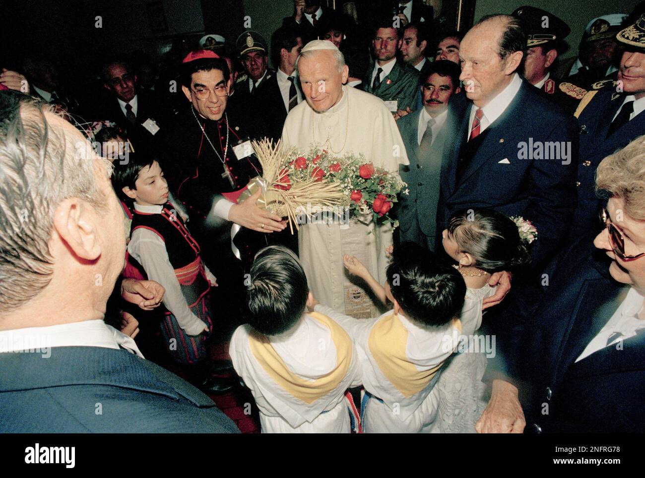Pope John Paul II holds flowers at left after receiving them from three ...